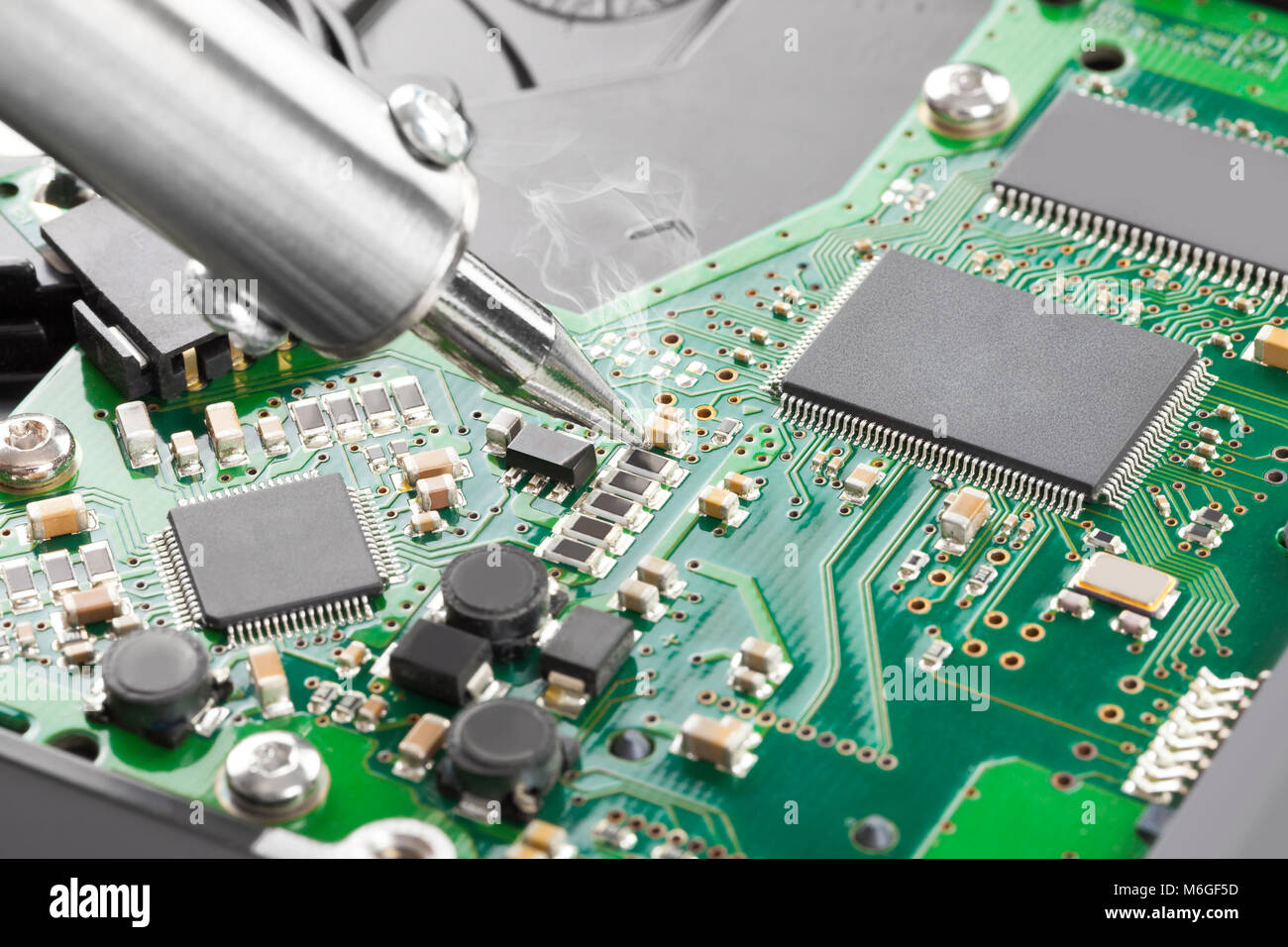 Soldering iron and green microcircuit - close up studio shot Stock ...