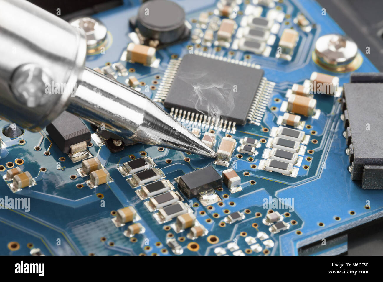 Soldering iron and blue microcircuit - close up studio shot Stock Photo ...