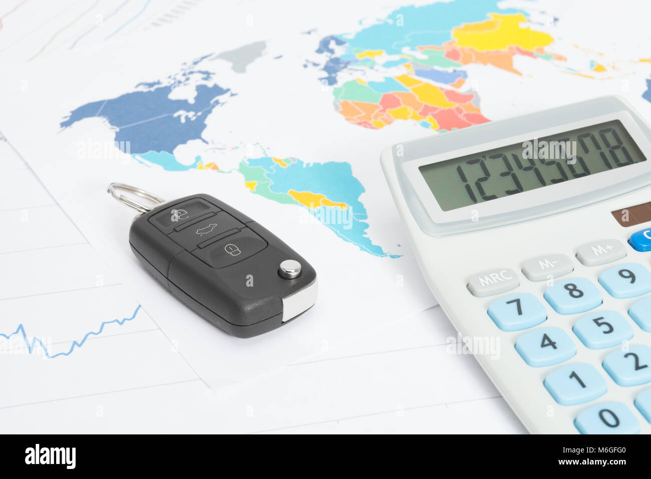 Car key and calculator over print with world map Stock Photo - Alamy