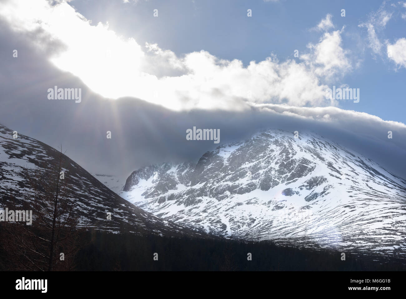 The sun breaks through the cloud above the north face of Ben Nevis on a ...