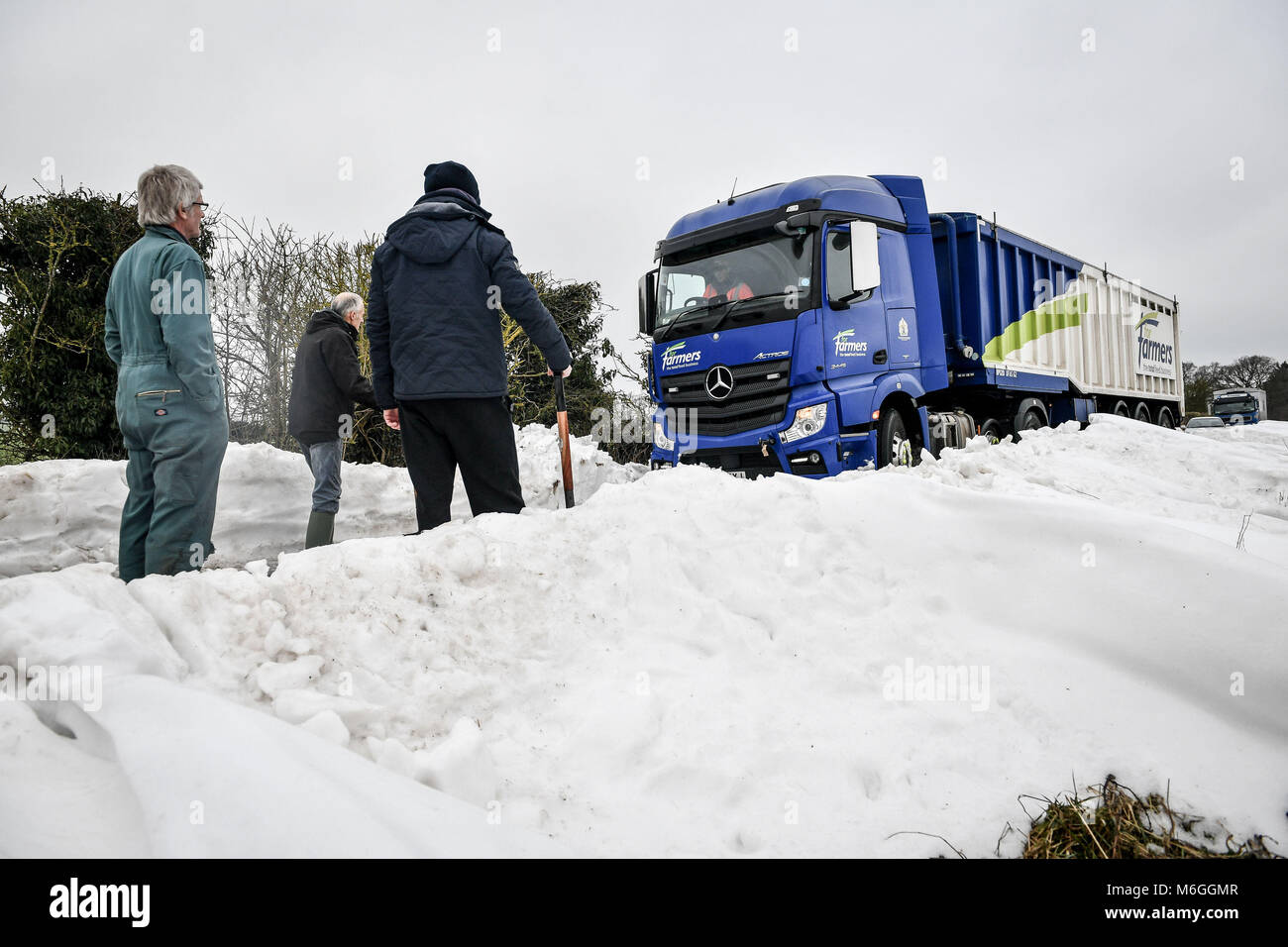 Men use shovels to try free a lorry stuck in snow on Draycott Close ...