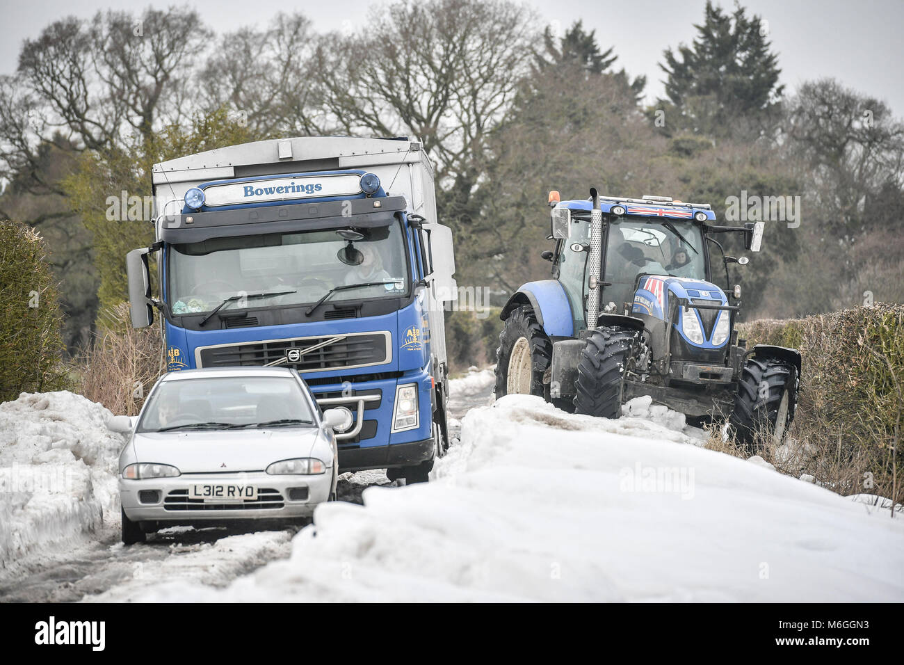 A tractor tries to pass vehicles stuck behind a trapped lorry stuck in ...