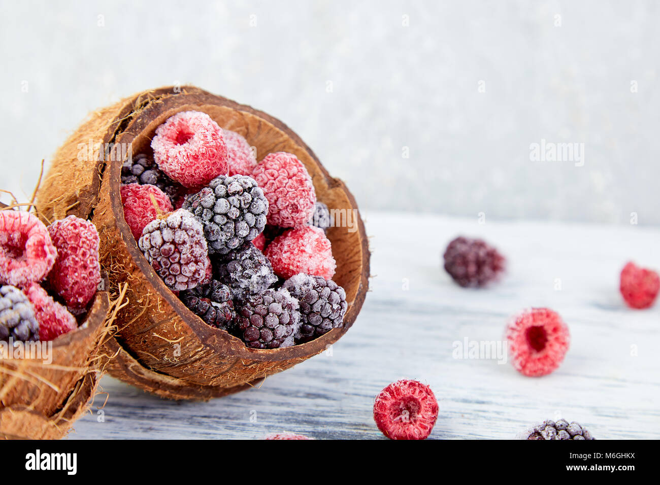 Frozen black and red raspberries in coconut bowl Stock Photo - Alamy