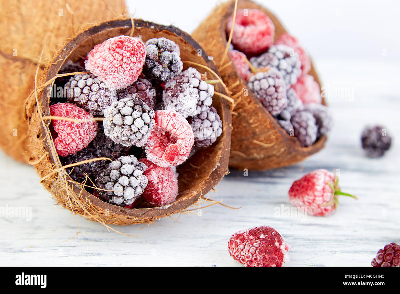 Frozen black and red raspberries in coconut bowl Stock Photo - Alamy