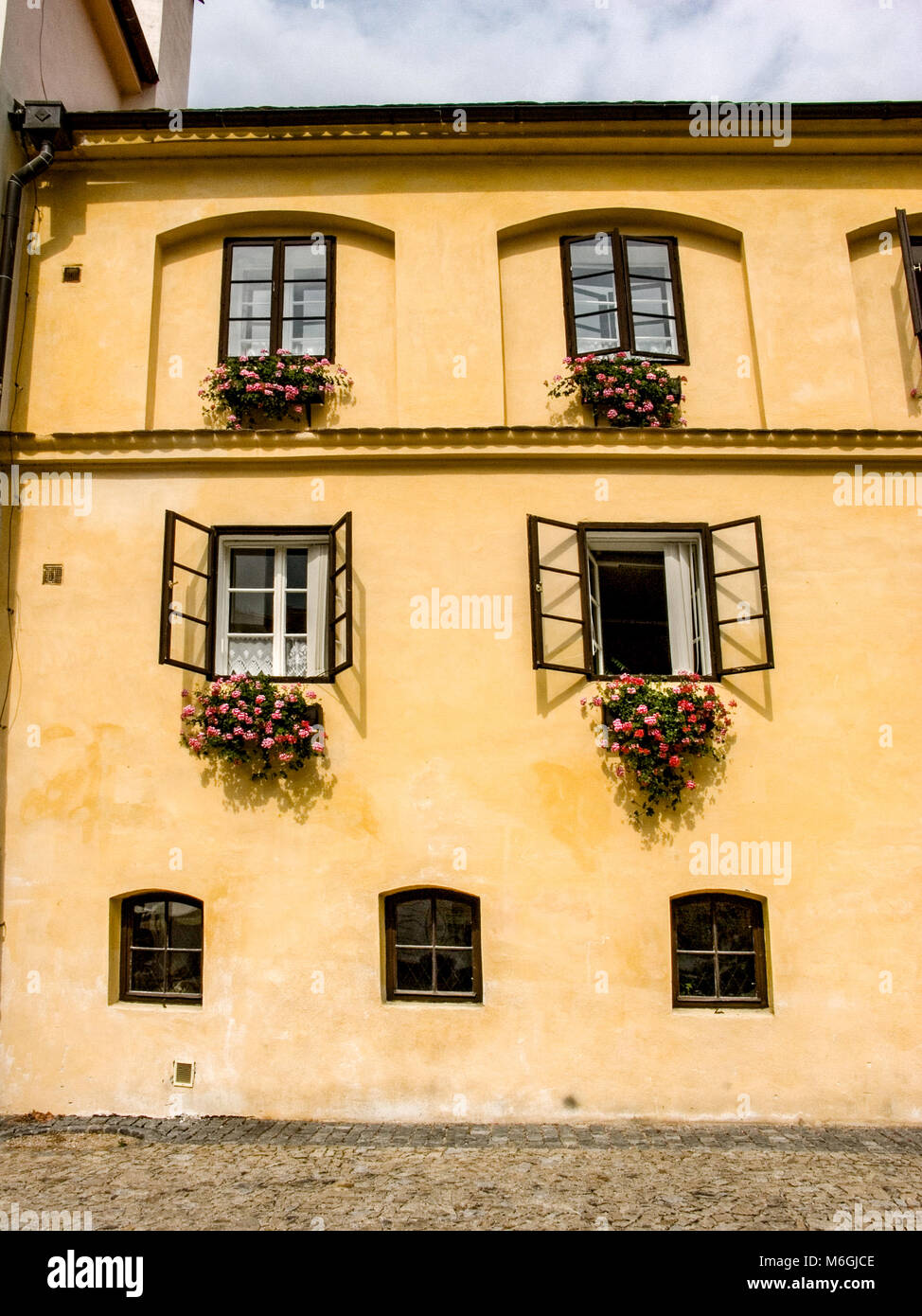 Facade of an old house with flowers under the windows Stock Photo - Alamy