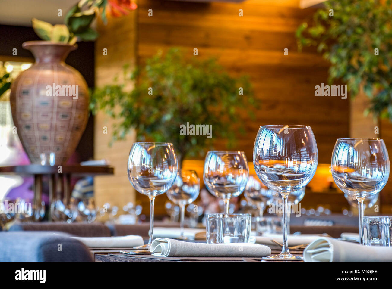 Elegant dining table set in a restaurant, featuring wine glasses, cutlery, and fine tableware ...