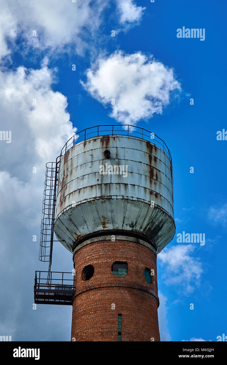 High water-pressure tower made of brick and metal with round windows ...