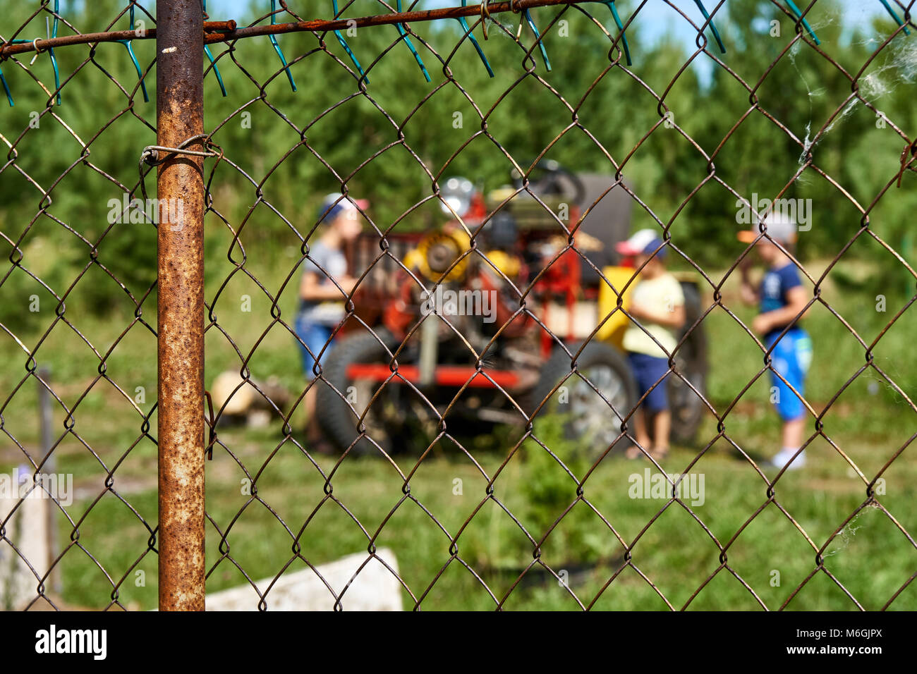 Mesh rusty fence against the background of playing children Stock Photo ...