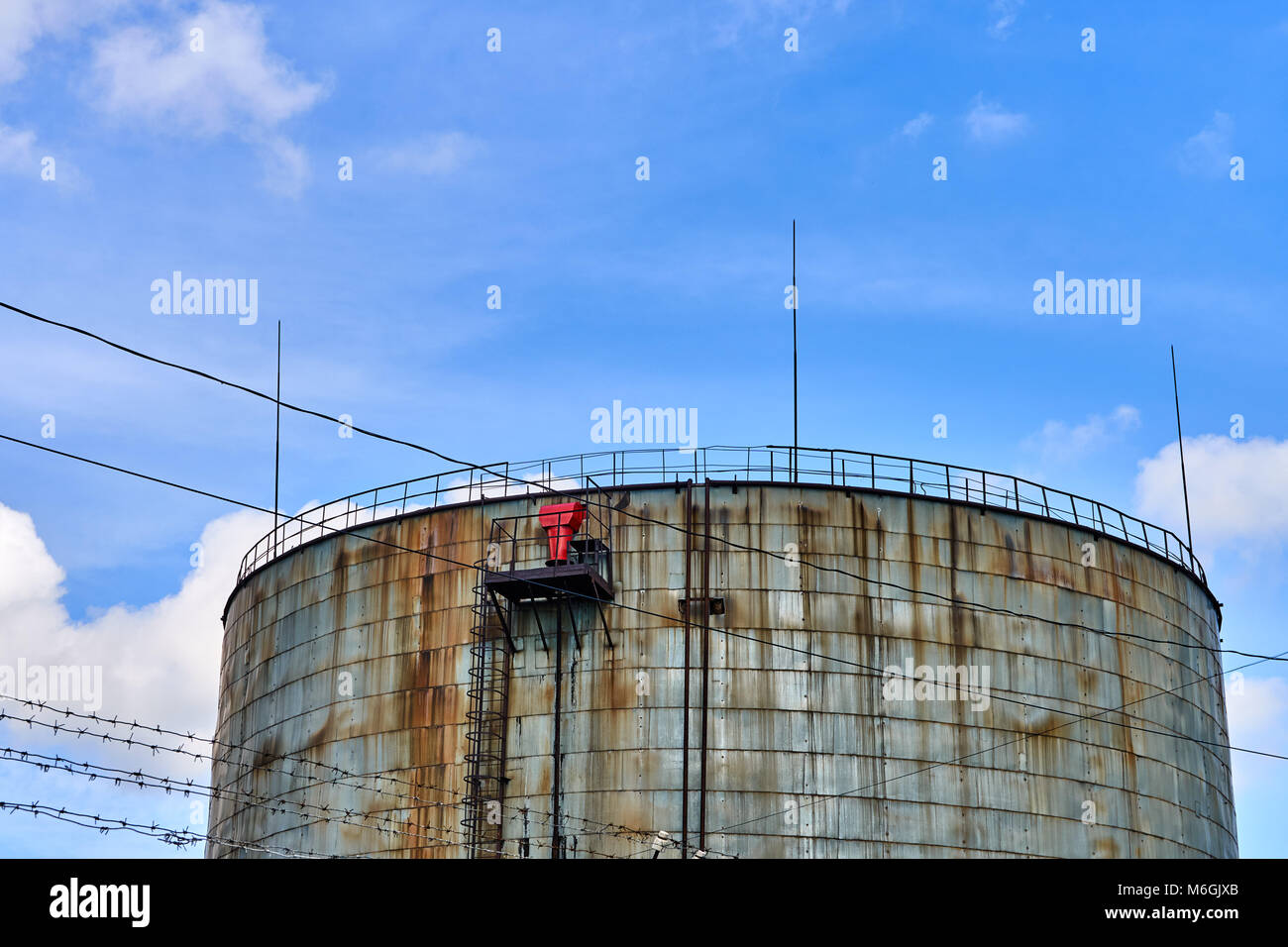 Old rusty industrial fuel storage tank against blue cloudy sky Stock ...