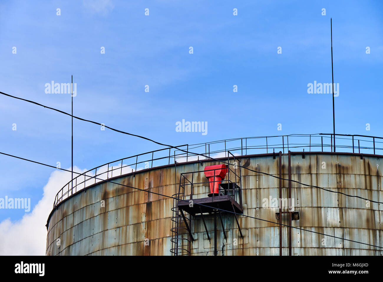 Old rusty industrial fuel storage tank against blue cloudy sky Stock ...
