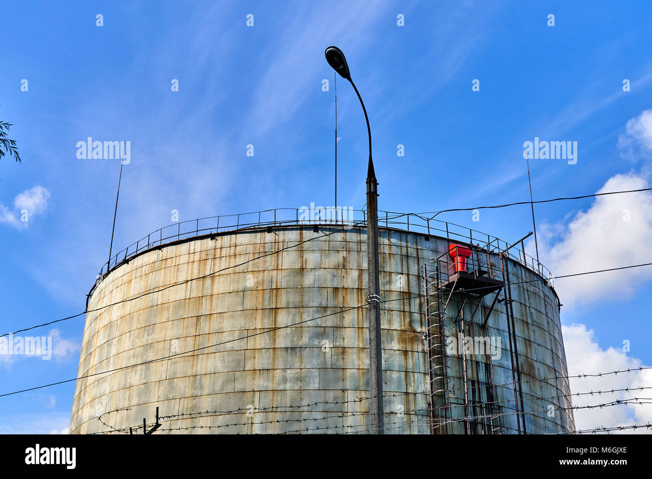 Old rusty industrial fuel storage tank against blue cloudy sky Stock ...