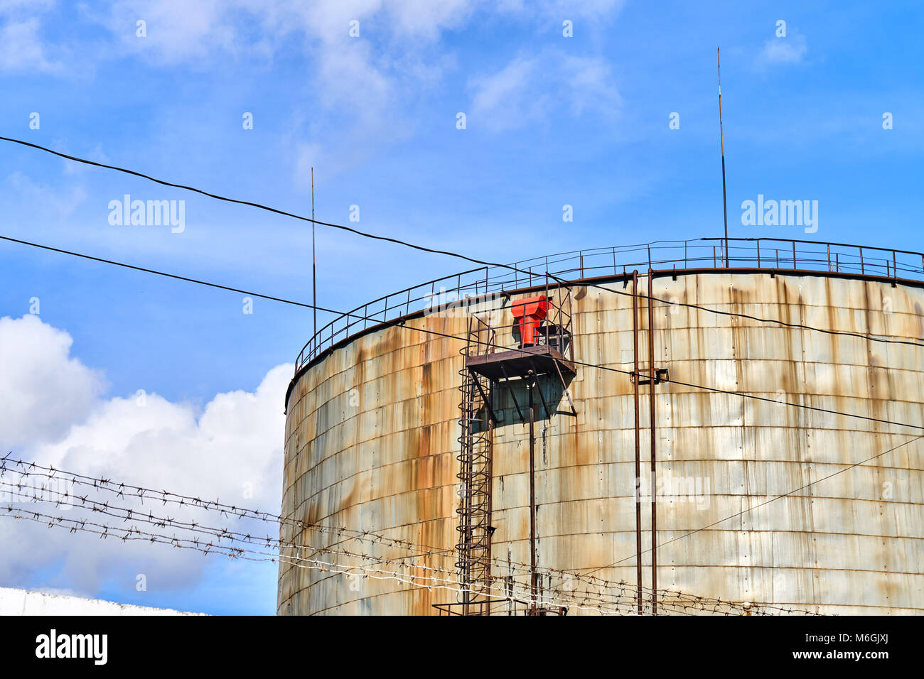 Old rusty industrial fuel storage tank against blue cloudy sky Stock ...
