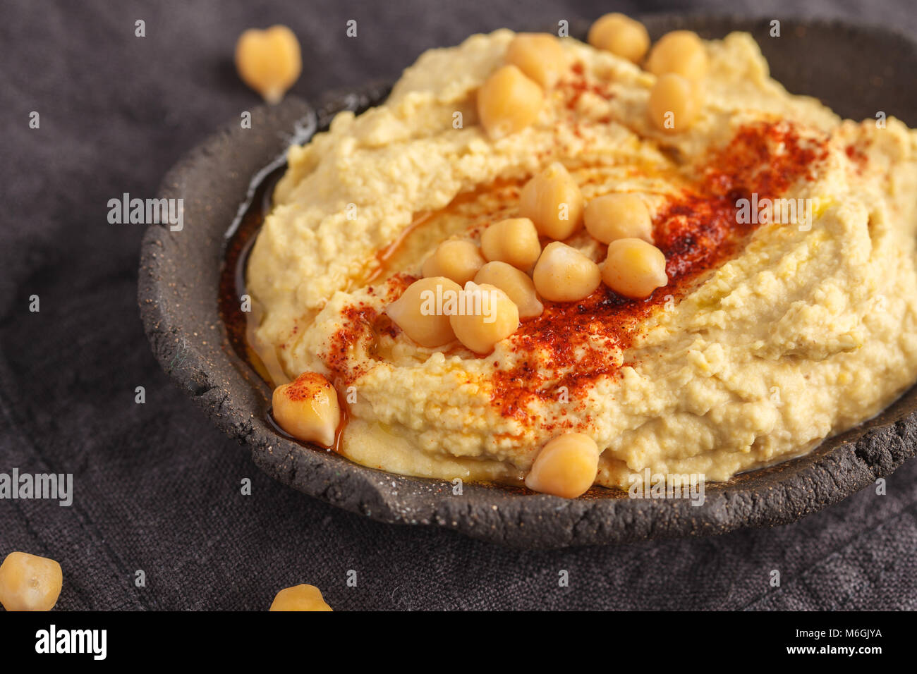 Homemade traditional hummus in a clay dish, dark background, top view ...