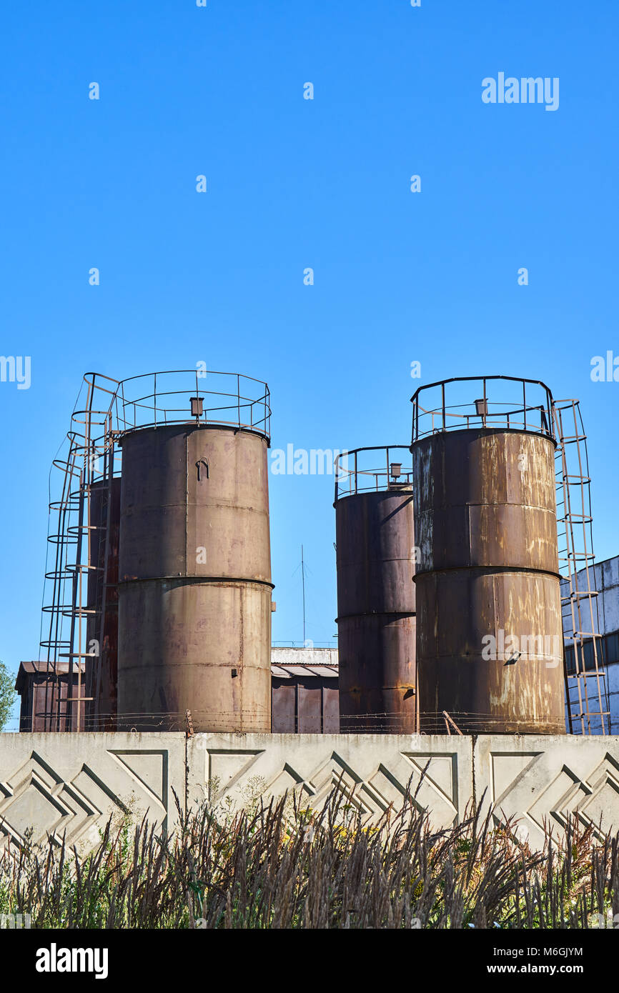 Old rusty industrial fuel storage tanks against blue sky Stock Photo ...