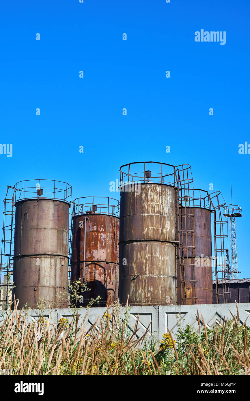 Old rusty industrial fuel storage tanks against blue sky Stock Photo ...