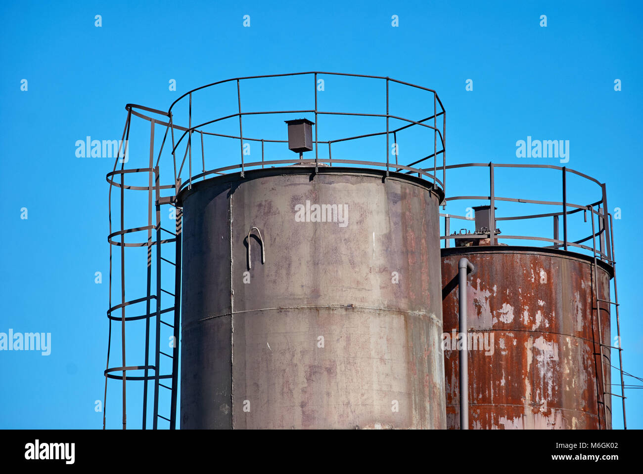 Old rusty industrial fuel storage tanks against blue sky Stock Photo ...