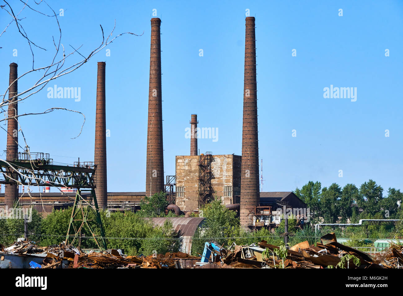 Abandoned industrial complex, with tall, weathered smokestacks towering ...