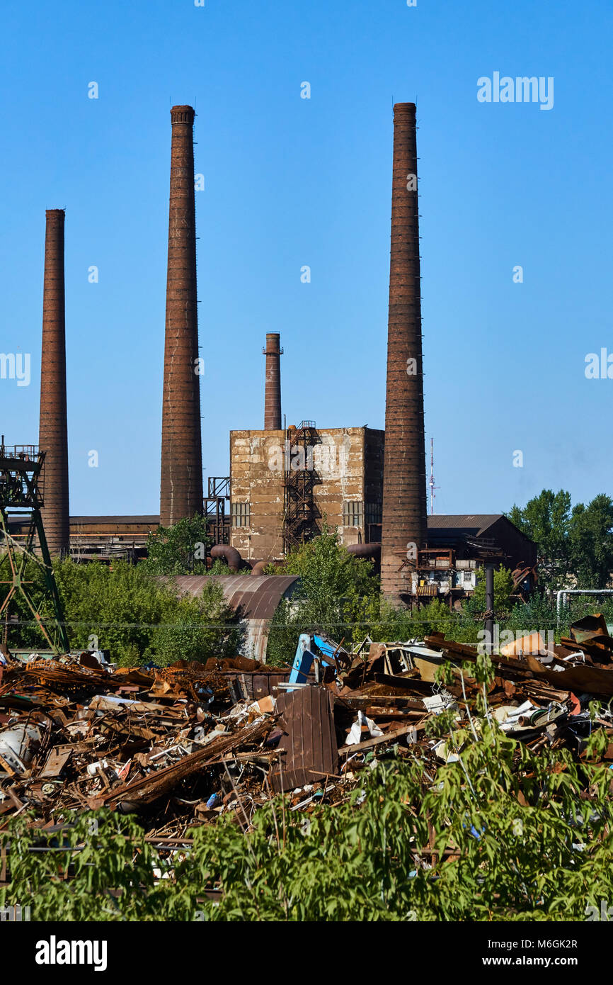 Abandoned industrial complex, with tall, weathered smokestacks towering ...