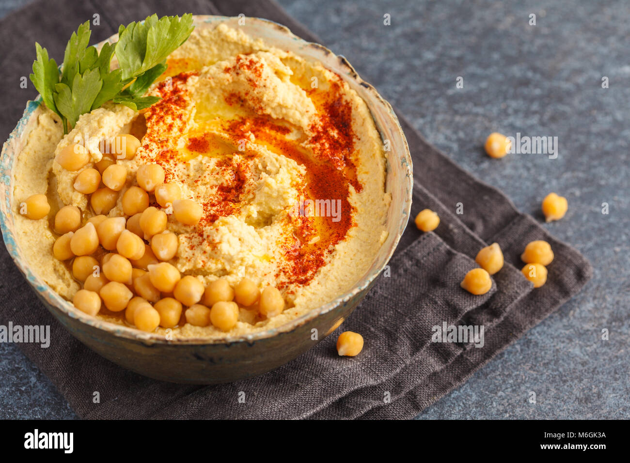 Homemade traditional hummus in a clay dish, dark background, top view ...