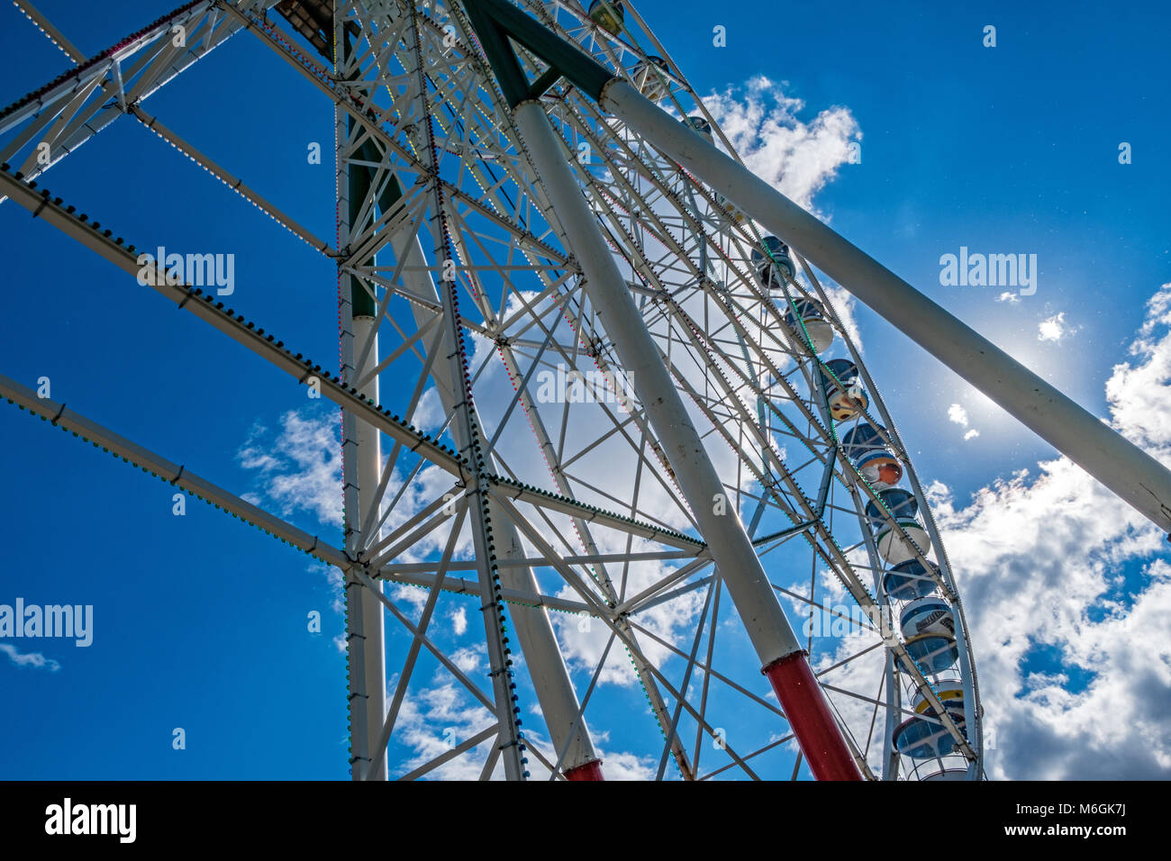 Huge Ferris wheel against cloudy sky in entertainment park low angle ...