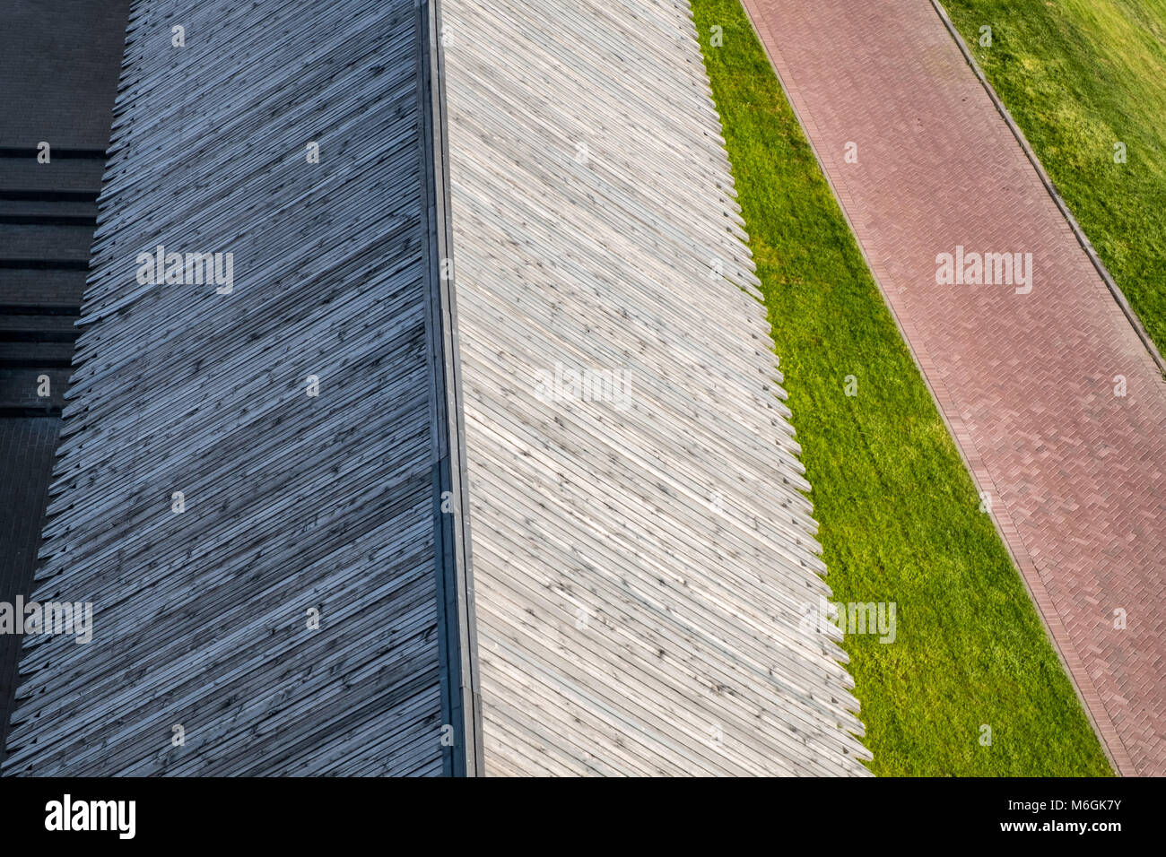 From above wooden roof of building located between green lawn with path ...