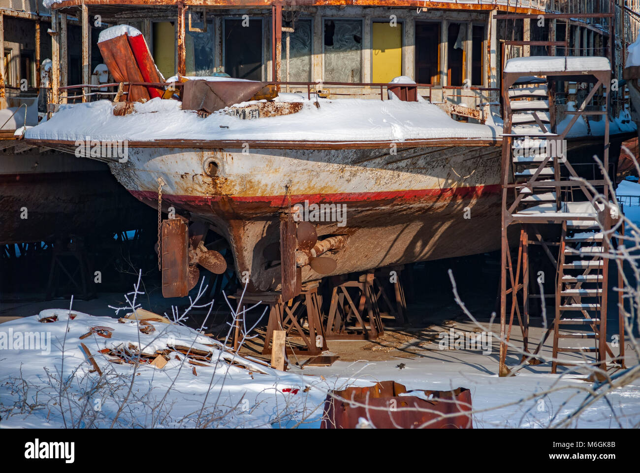 Old rusty ferries located near snowy shore of harbor against cloudless ...