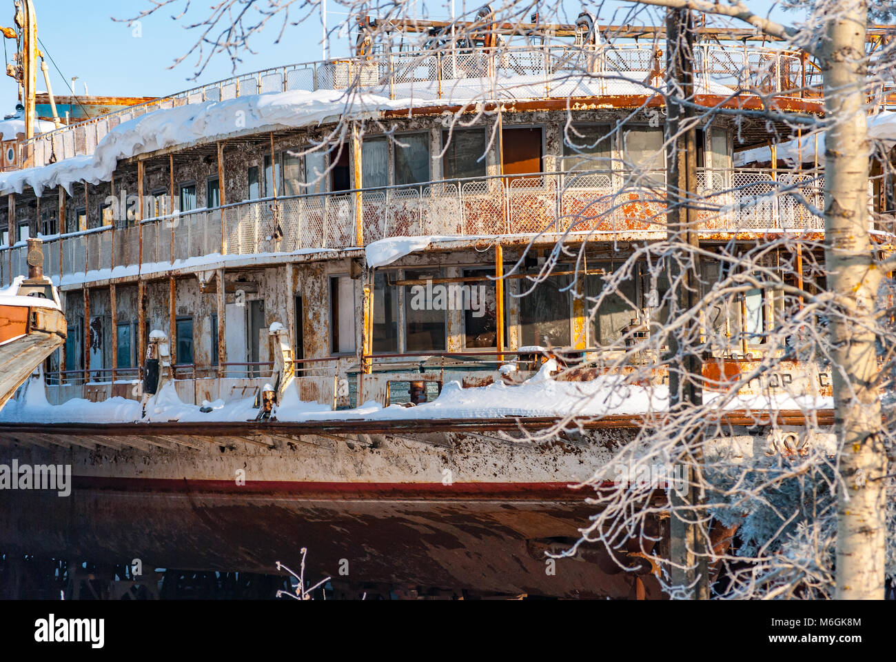 Old rusty ferries located near snowy shore of harbor against cloudless ...