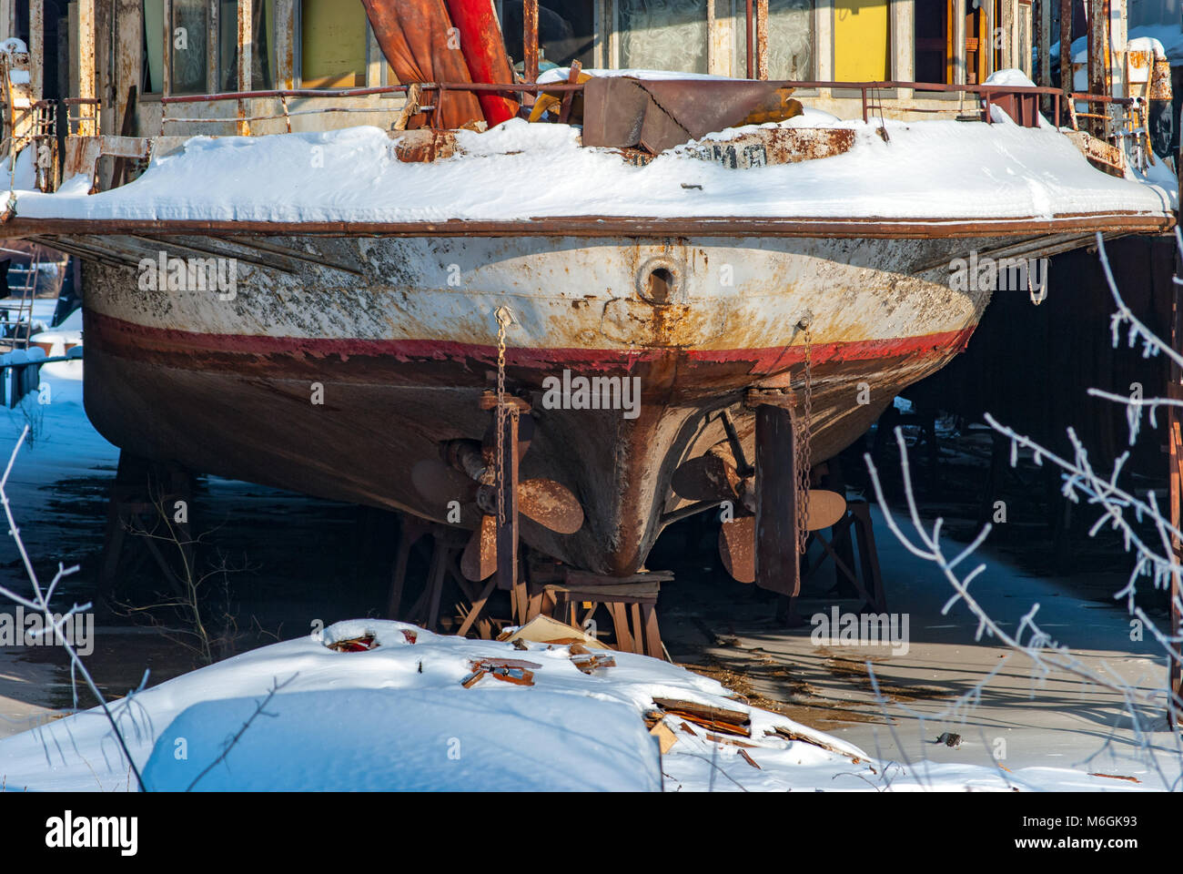 Old rusty ferries located near snowy shore of harbor against cloudless ...