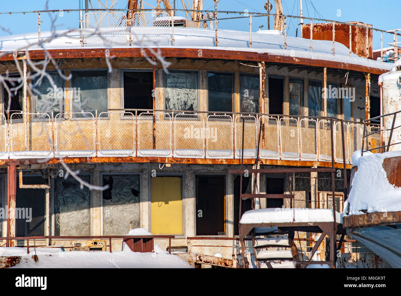 Old rusty ferries located near snowy shore of harbor against cloudless ...