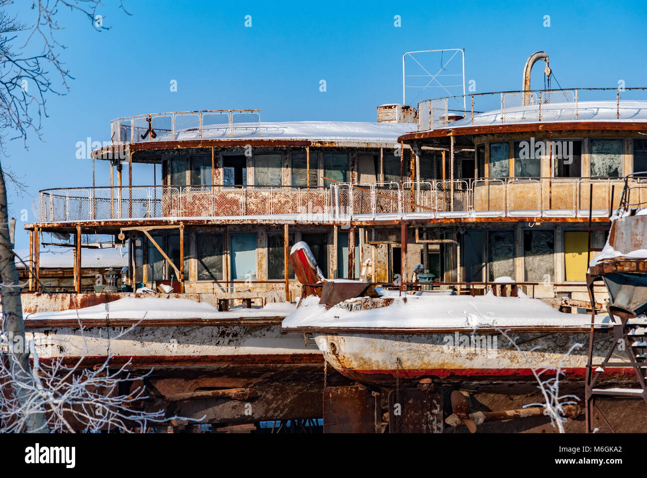 Old rusty ferries located near snowy shore of harbor against cloudless ...