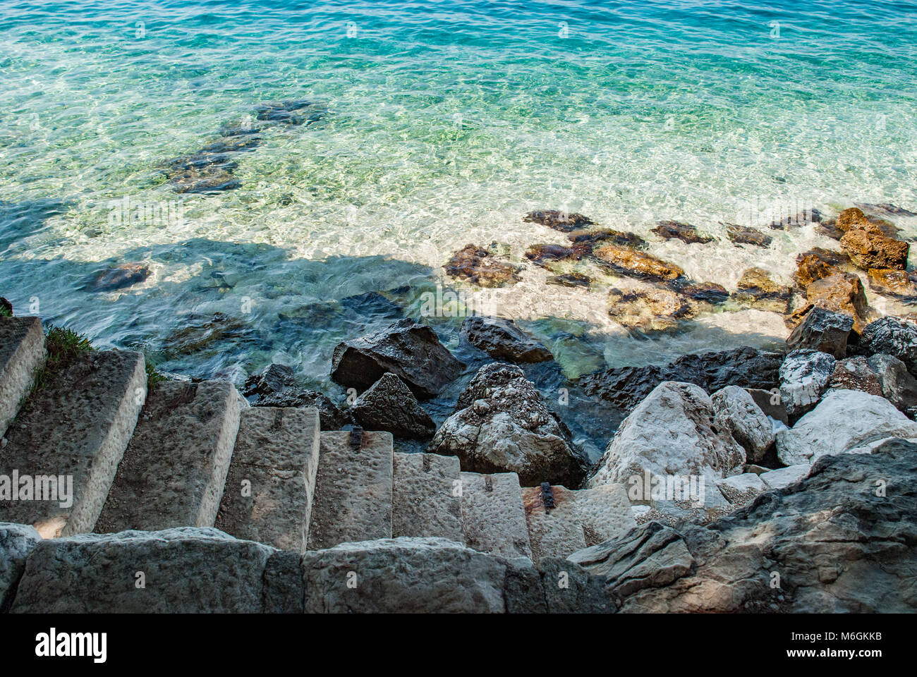Serene view of rough cut stone steps descending into mesmerizing clear ...