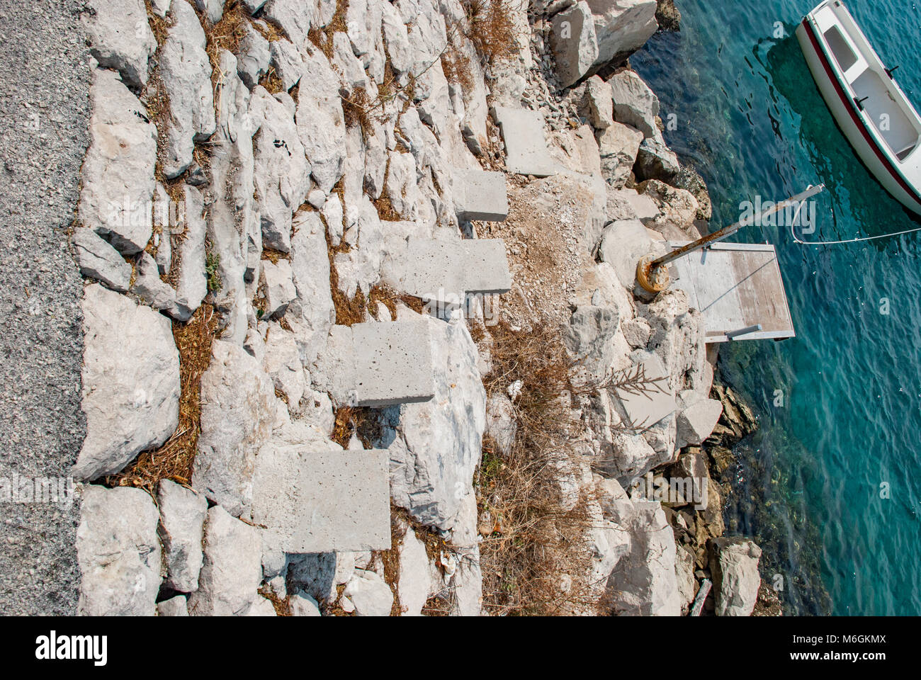 Stone steps leading to a private sea pier and moored boat Stock Photo ...
