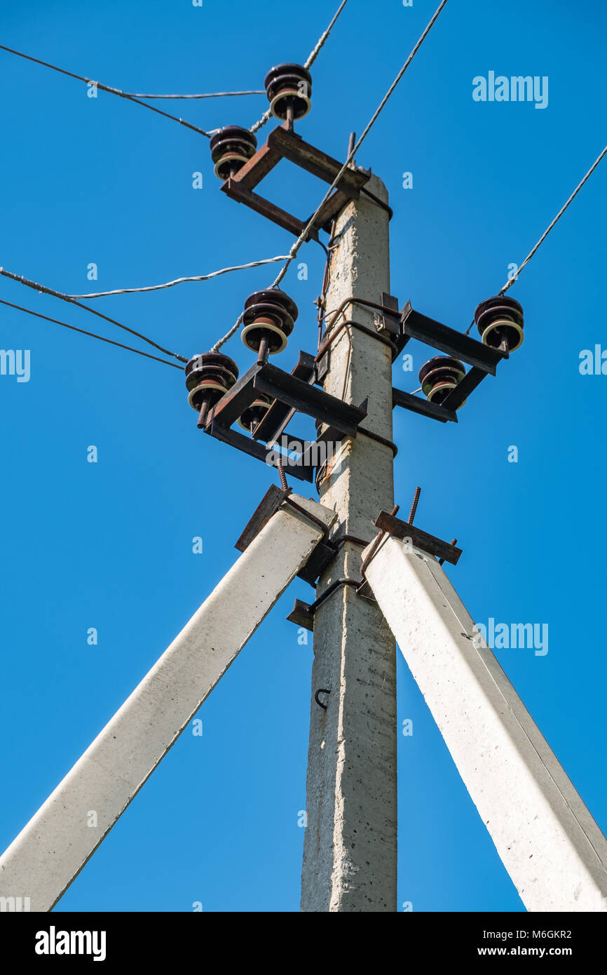 Electric pole and intersecting wires on a background of blue sky in ...