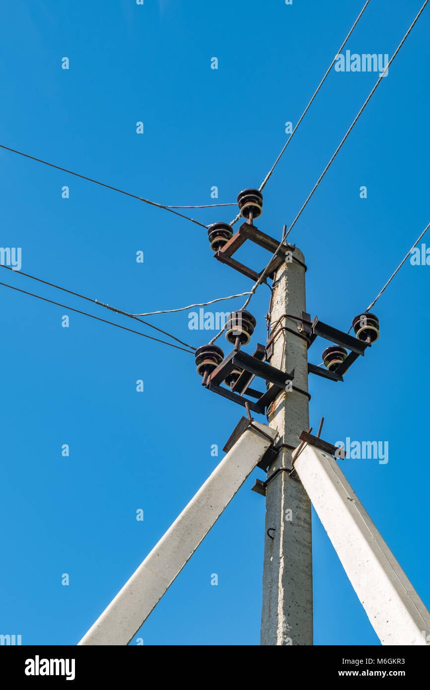 Electric pole and intersecting wires on a background of blue sky in ...