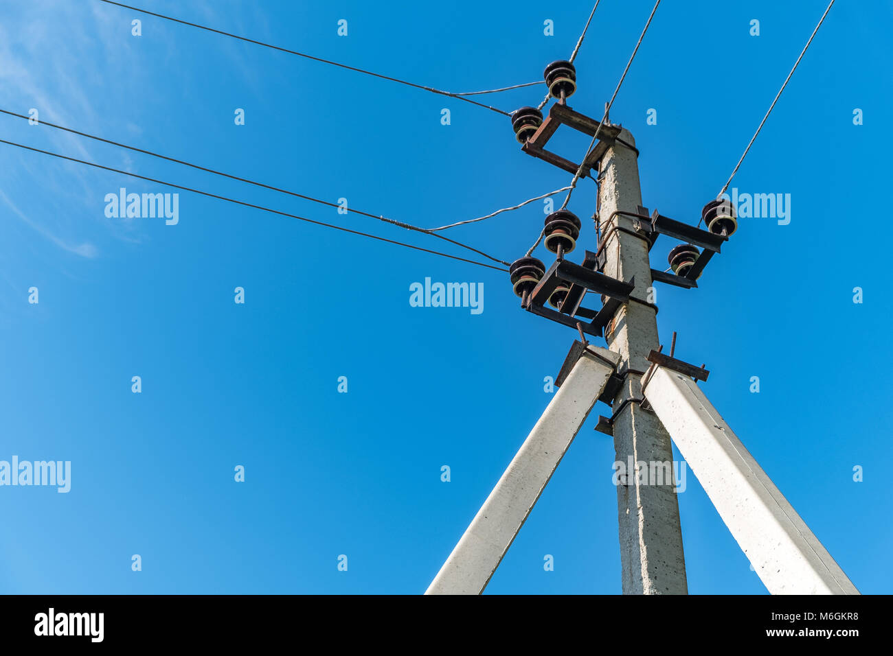 Electric pole and intersecting wires on a background of blue sky in ...