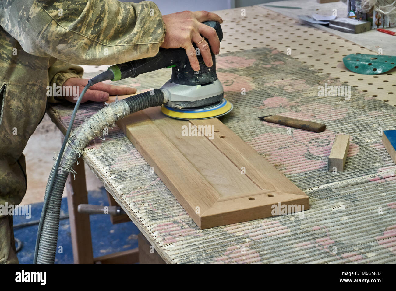 Joinery. Woodworker sanding wooden furniture element in workshop Stock ...