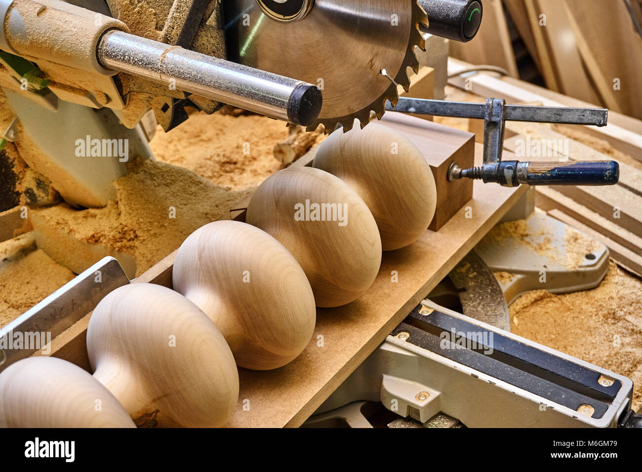 Joinery. Cut wooden leg with miter saw in workshop. Wooden furniture ...