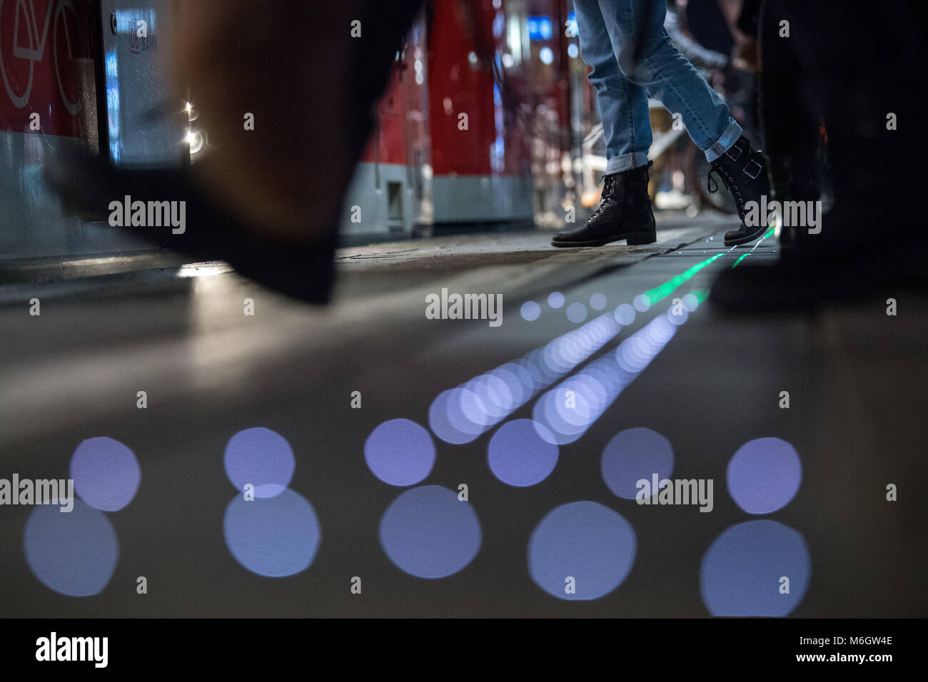 15 February 2018, Germany, Stuttgart: Pedestrians step over a lit ...