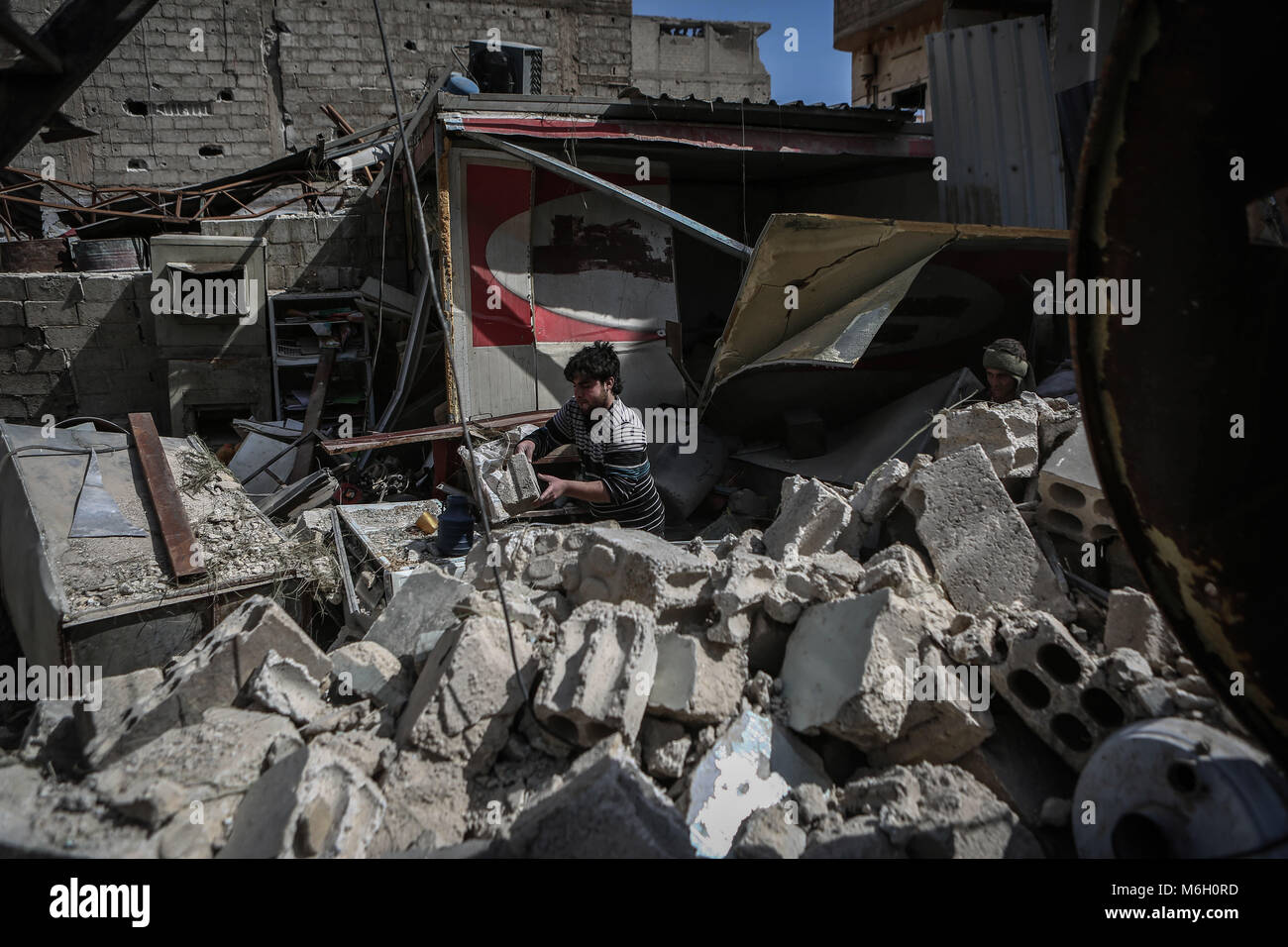 Syrians look for salvageable items in a destroyed house in the rebel ...