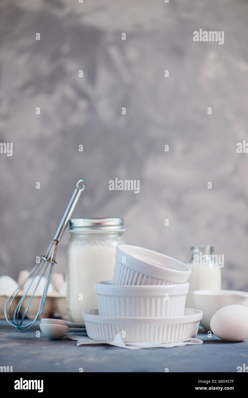 Baking forms in cooking concept with eggs, flour and milk on a concrete ...