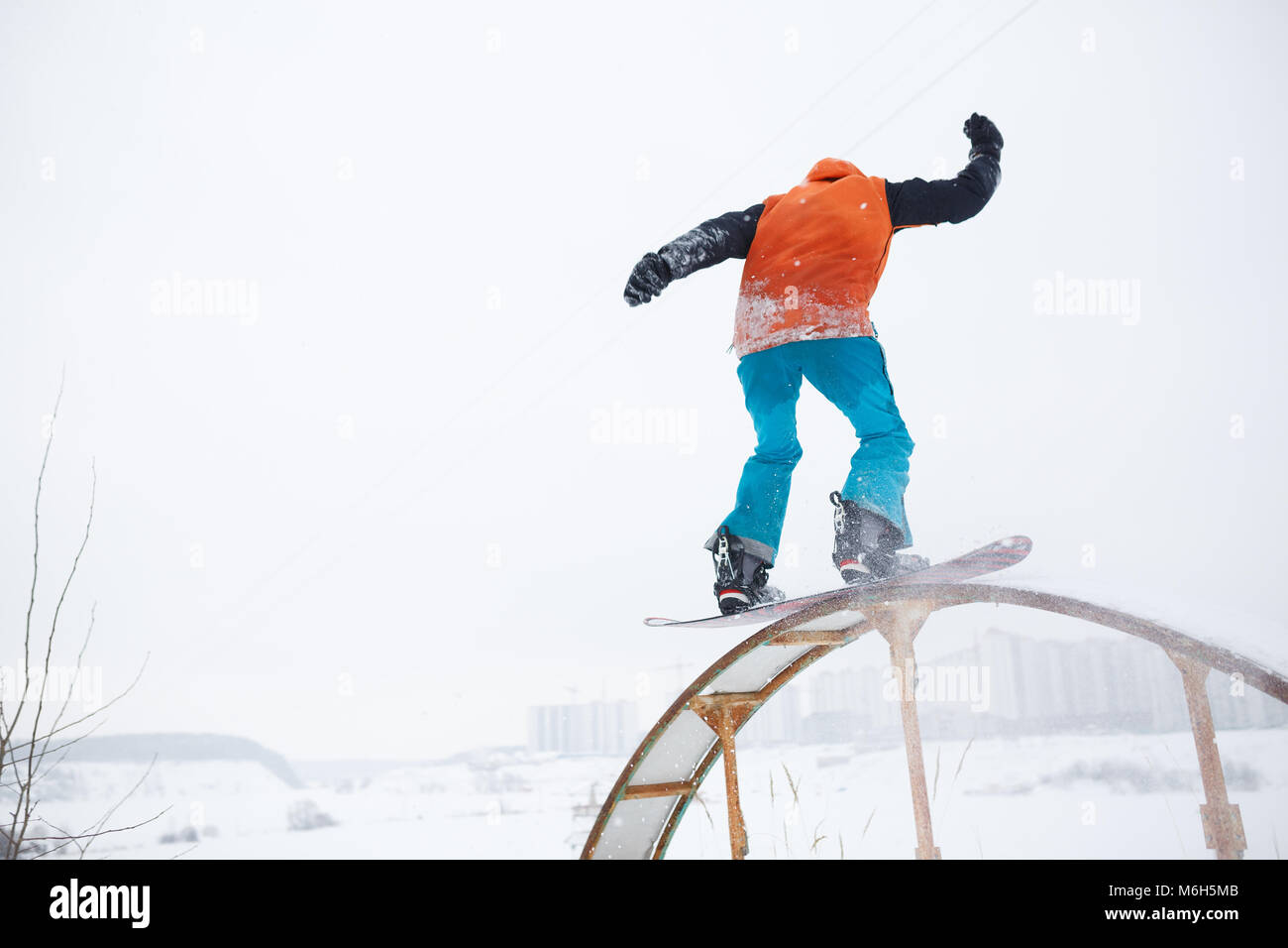 Picture from back of athlete skating on snowboard with springboard ...