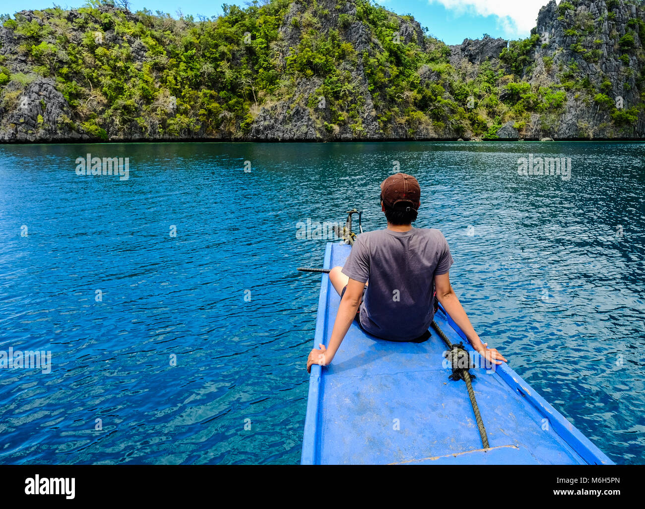 A man sitting on wooden boat in Coron Island, Philippines Stock Photo ...