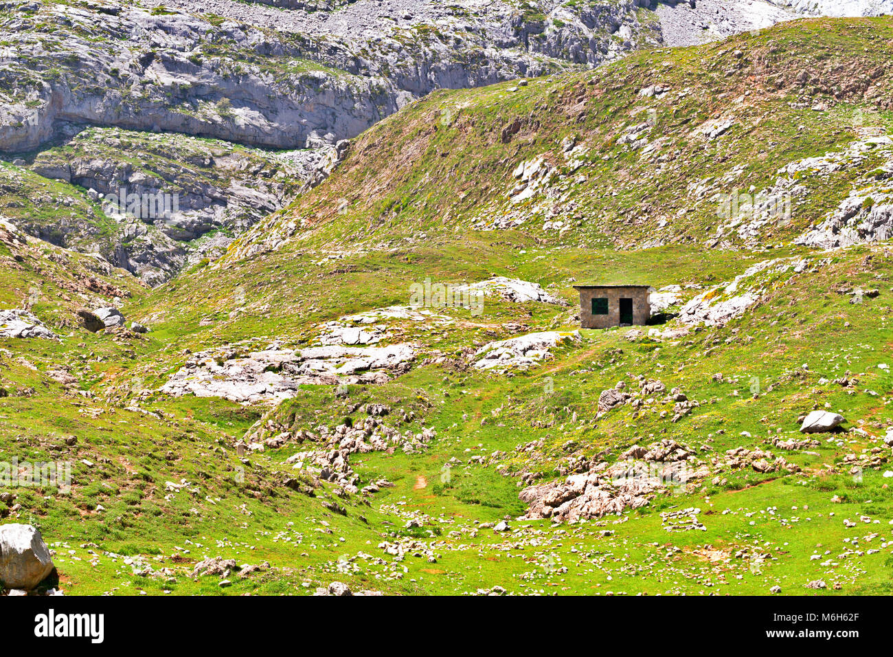 The small stone hut in mountains. Around a lodge the stones covered ...