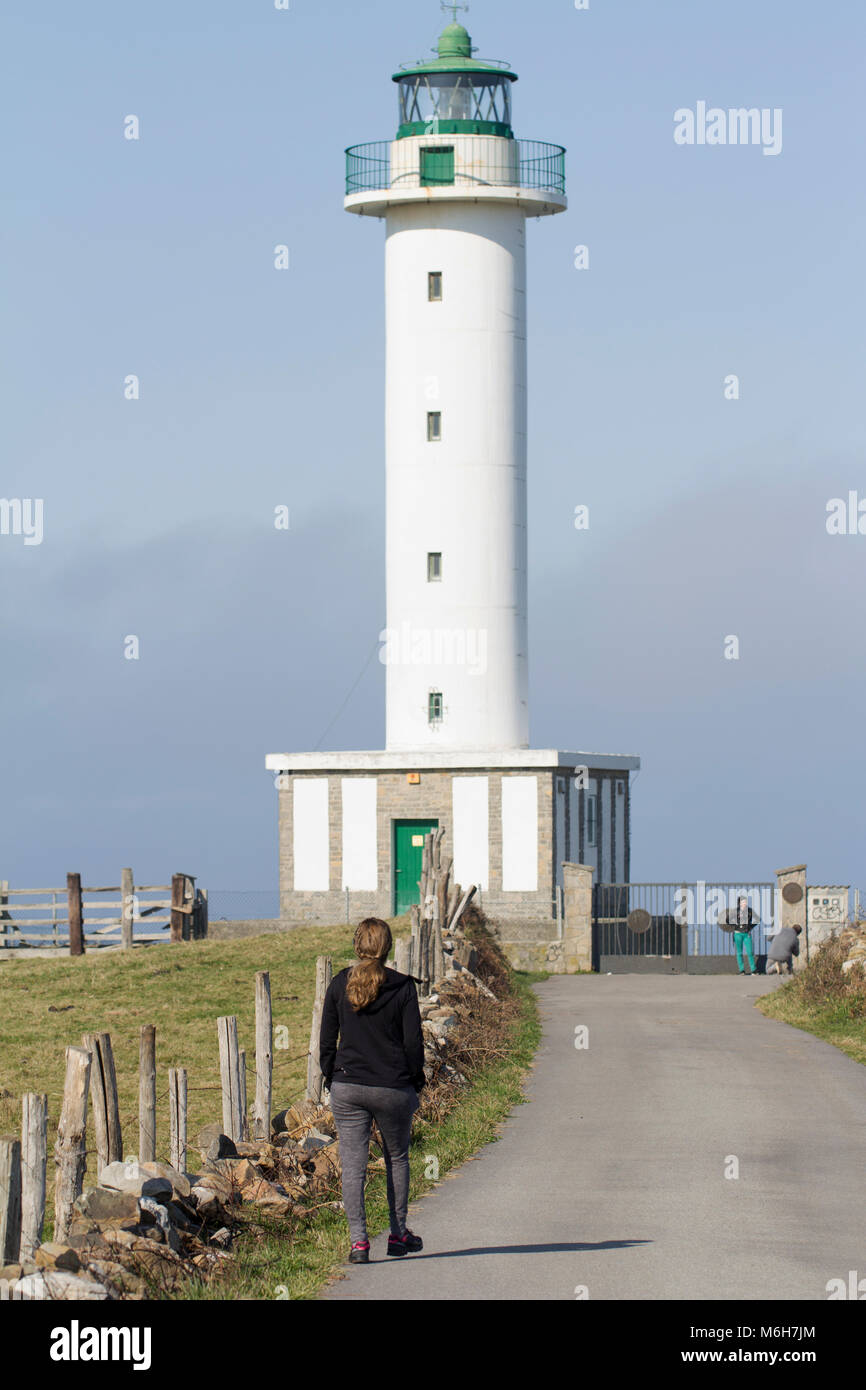One woman is walking to a lighthouse Stock Photo - Alamy