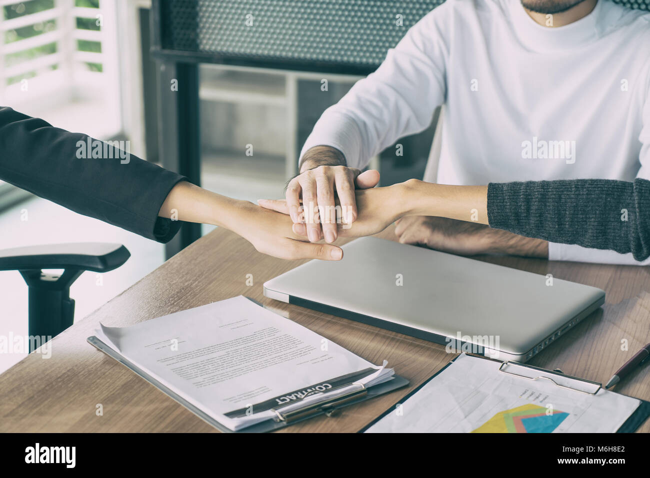 Three business partners team with hands together to greeting start up ...