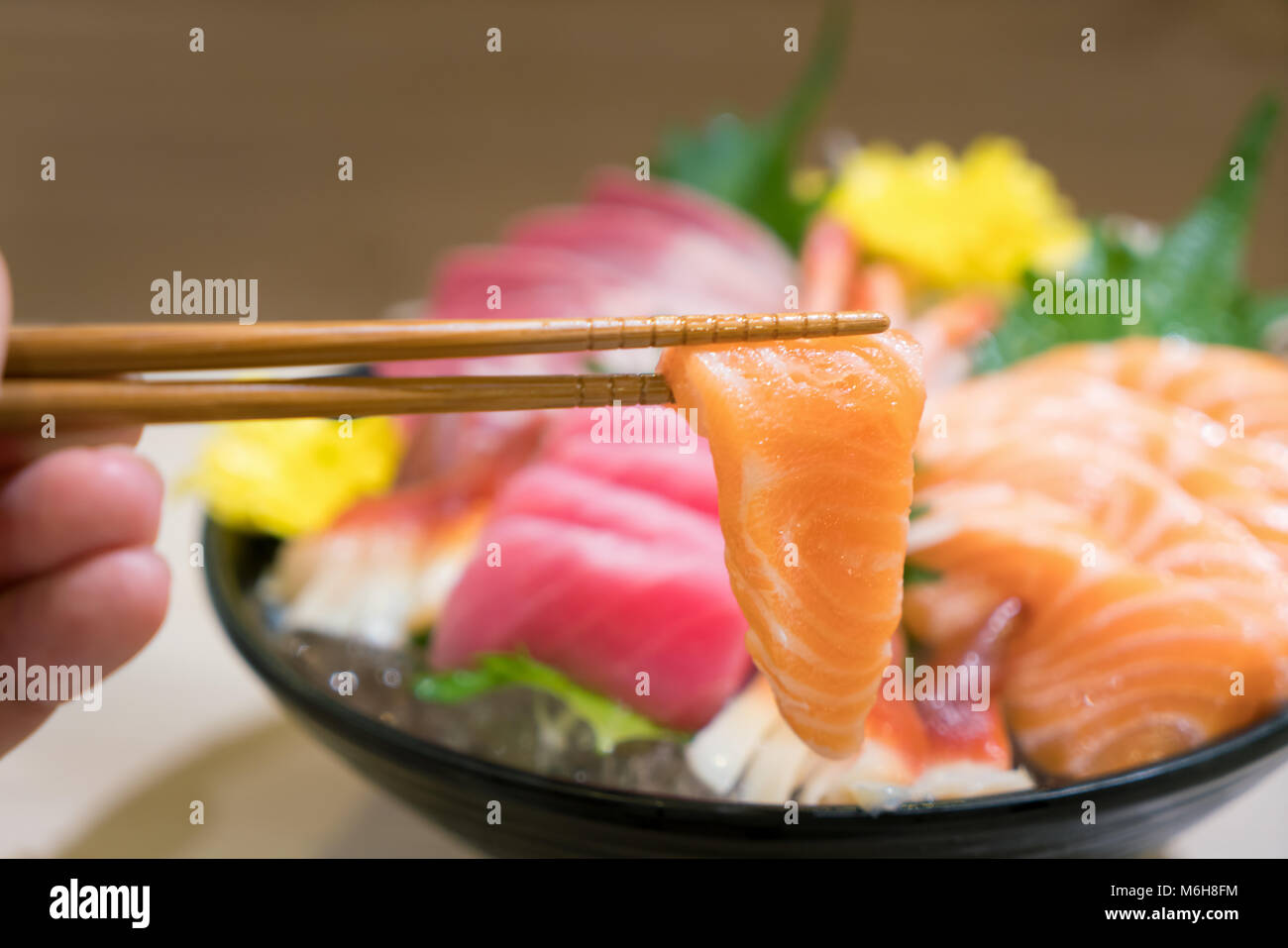 Chopsticks with Salmon sashimi with Mixed sliced fish sashimi on ice in ...