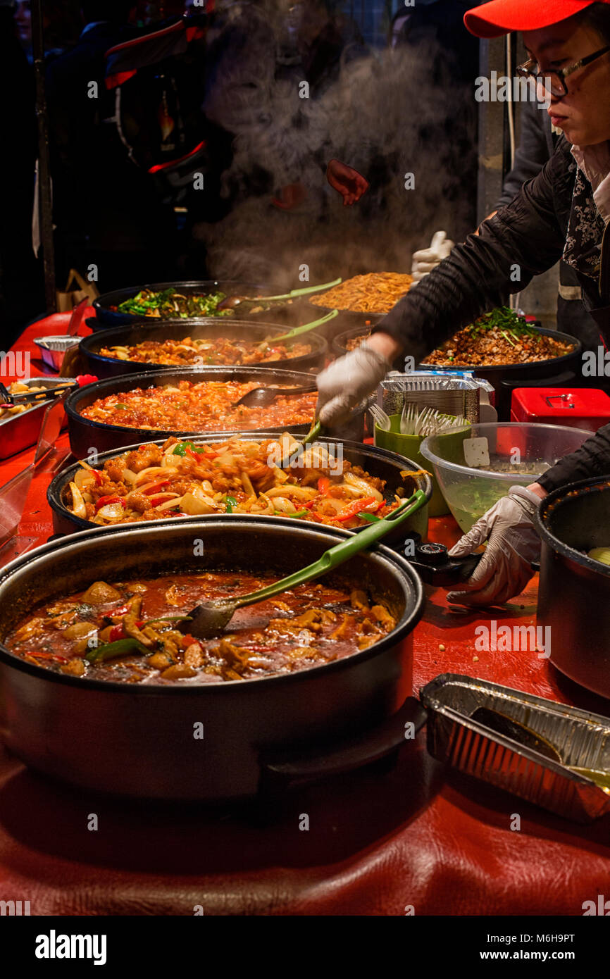 LONDON, UK-FEBR 11,2018: Malaysian cook is stirring in the food cooking ...