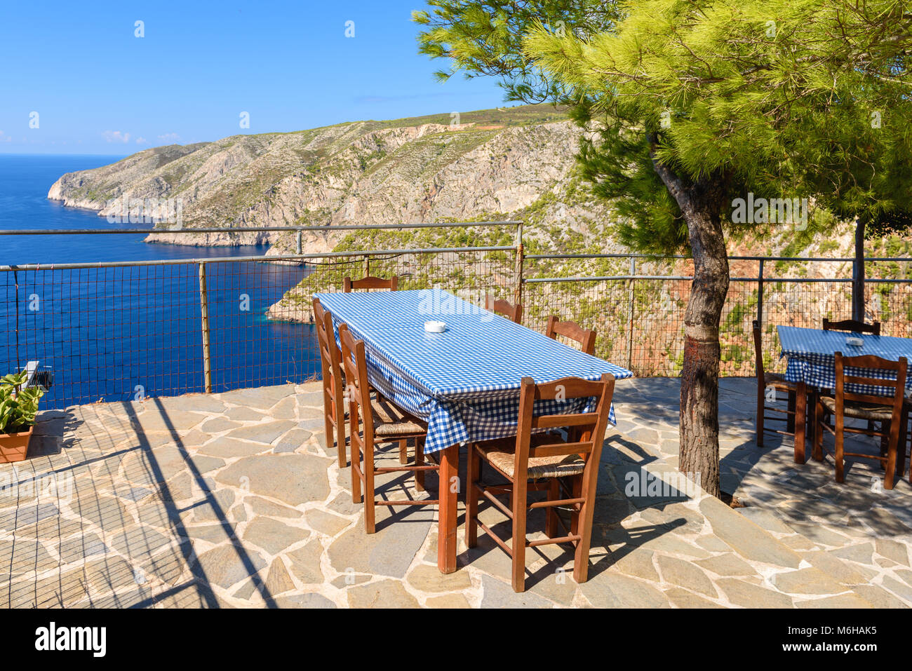 Tables with chairs on terrace of coastal restaurant in Porto Schiza on ...