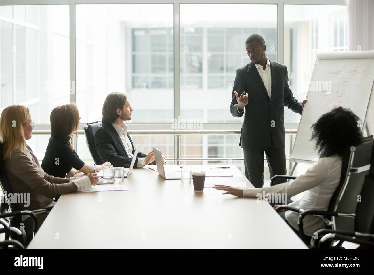 Black coach giving presentation to clients at conference meeting Stock ...