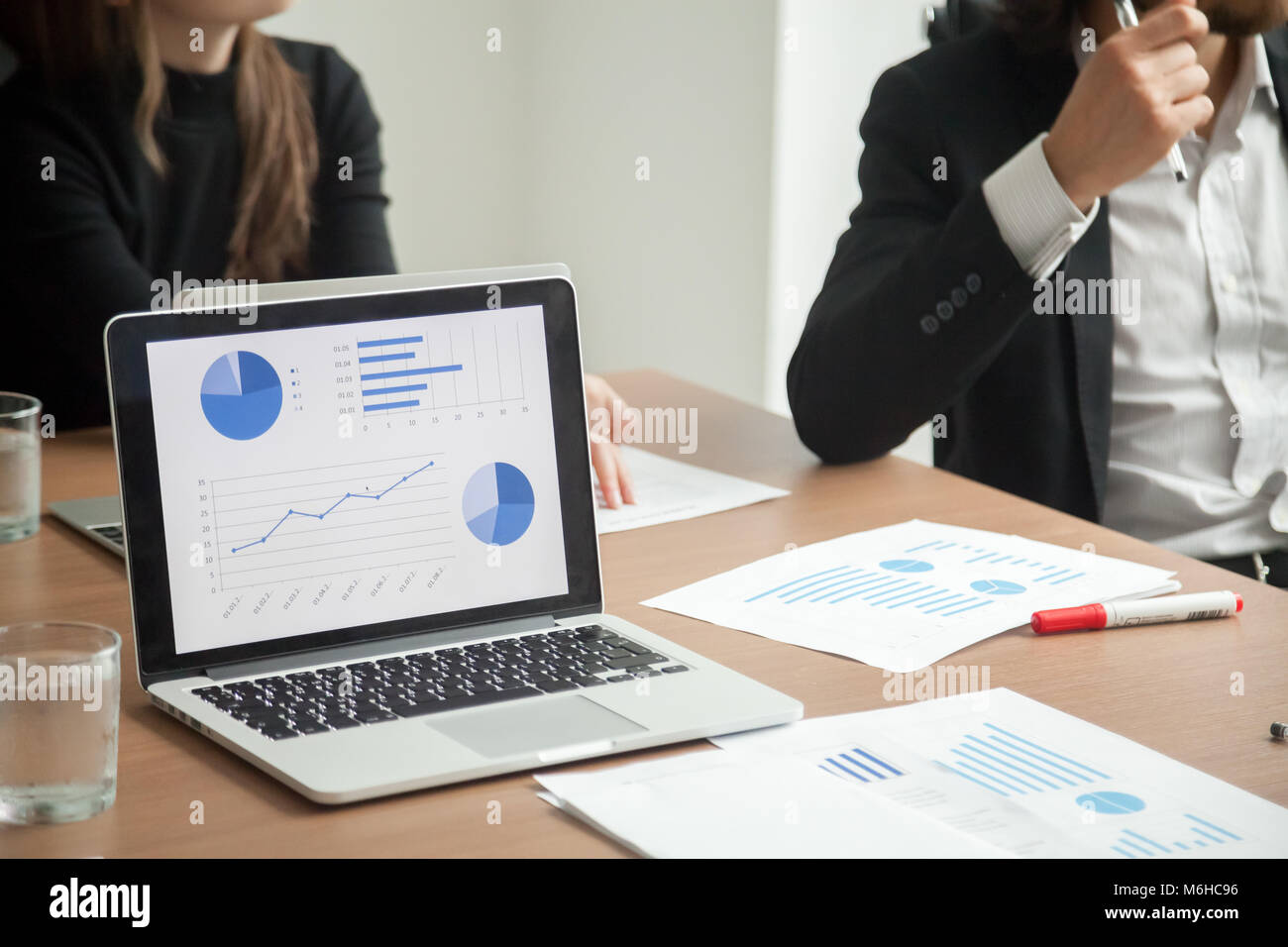 Executive team analyzing statistics data at corporate meeting, c Stock ...